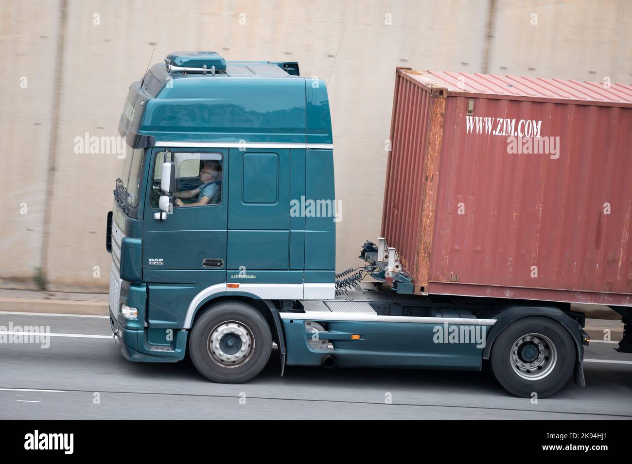 A green DAF XF truck loading a red container trailer along Barcelona's ...
