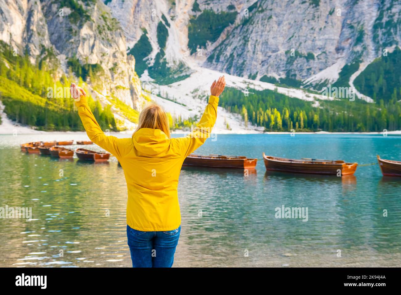 Tourist raised her hands and enjoys the view of Lake Braies with wooden ...