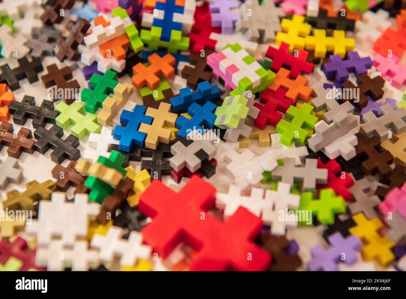 A pile of plastic toy puzzle pieces in various colors and sizes for ...