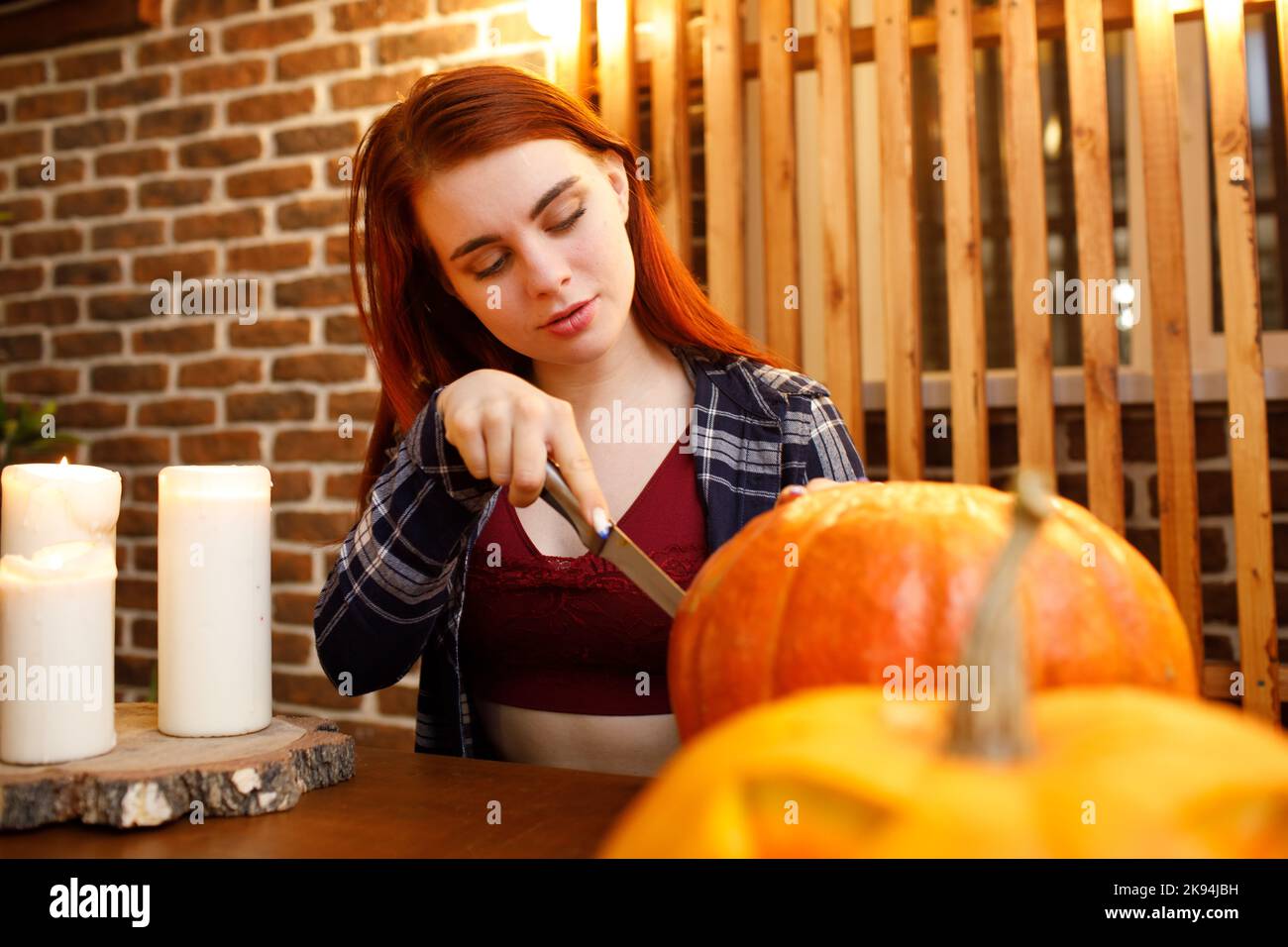 Young woman making Halloween pumpkin Jack-o-lantern. Female hands ...