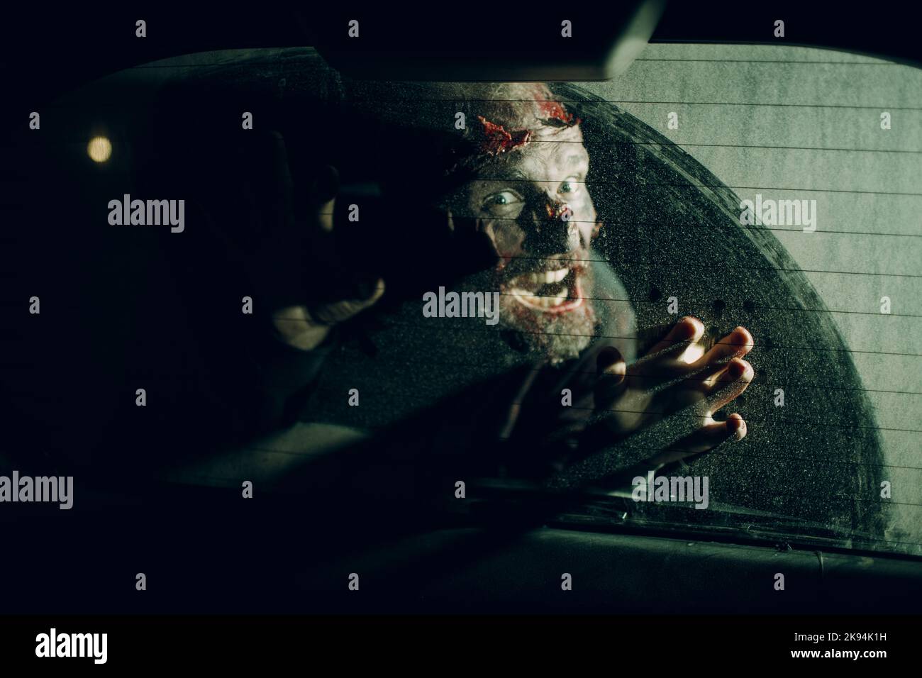 Zombie male attack car driver through vehicle window glass halloween ...