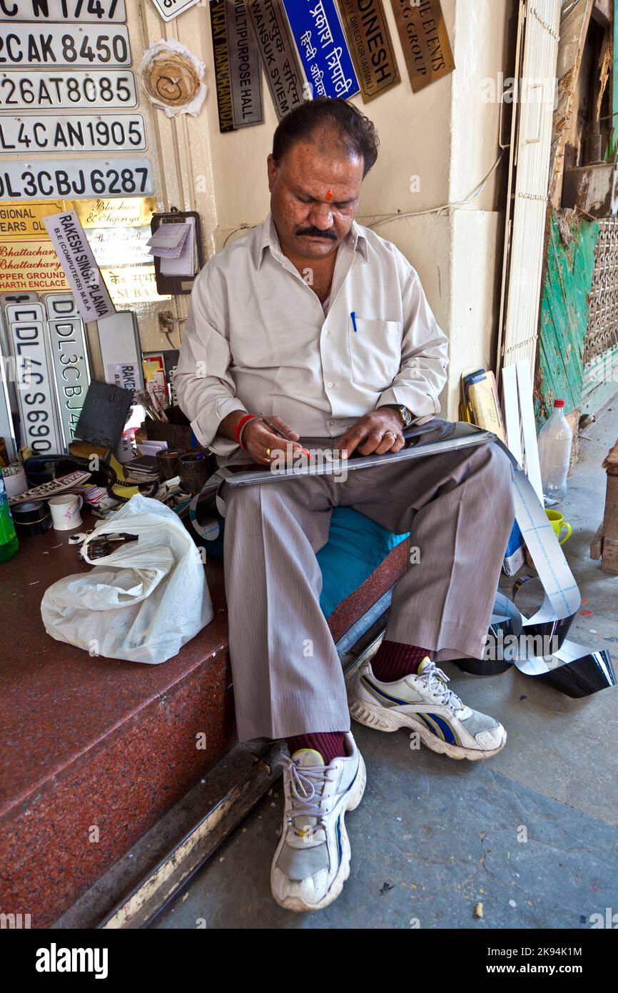 DELHI, INDIA - NOVEMBER 18: worker is painting car plates by hand on ...
