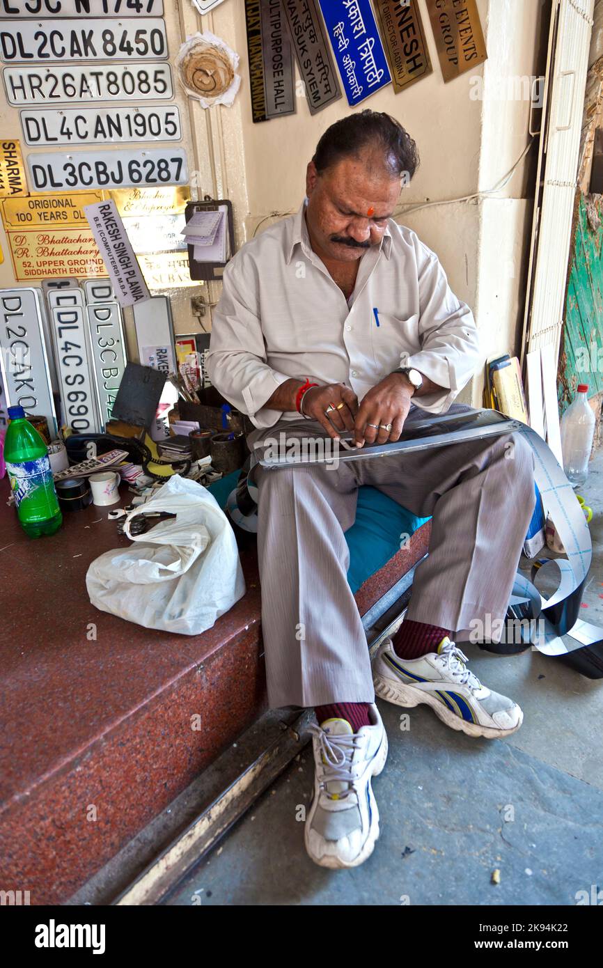 DELHI, INDIA - NOVEMBER 18: worker is painting car plates by hand on ...