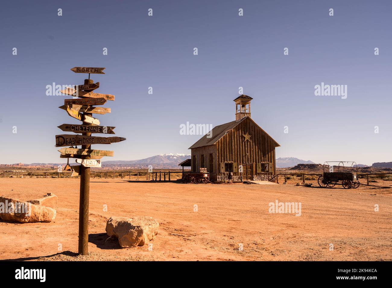 A signpost and an old wooden barn in Moab against a blue sky on a sunny ...