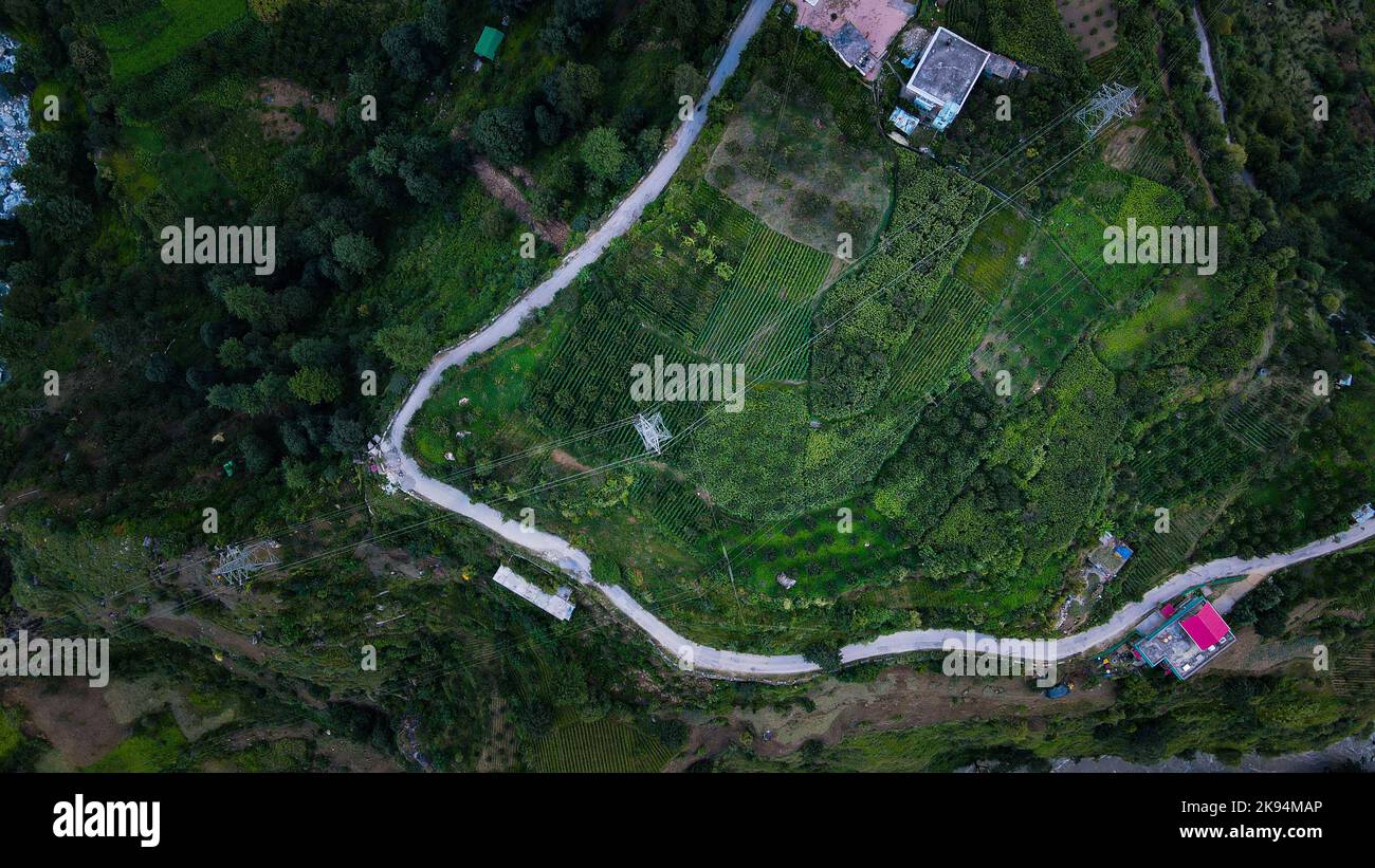 An aerial top view of a river flowing through green forests and rural houses on fields Stock ...