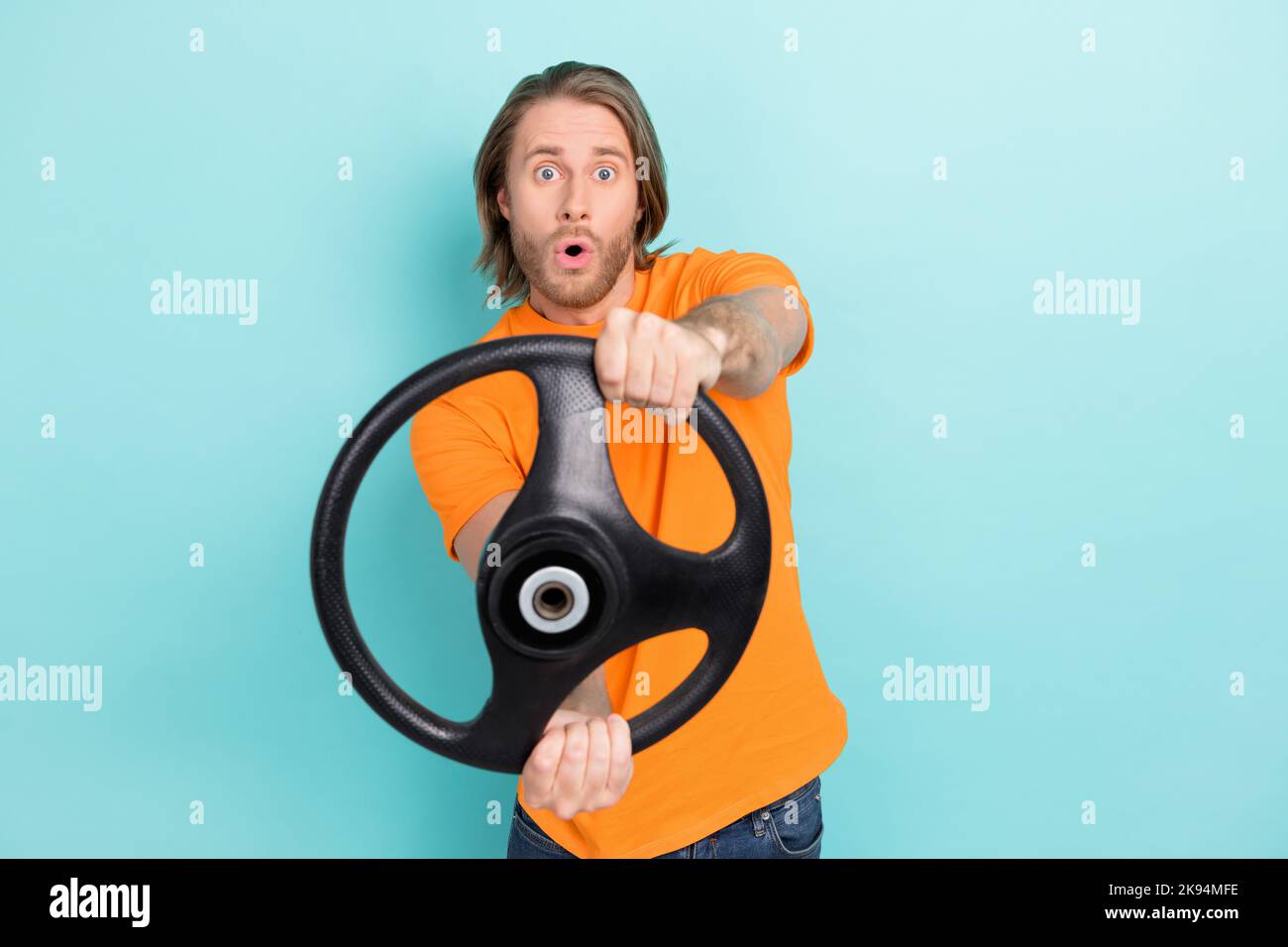 Photo of young bearded handsome funny man wear orange t-shirt driving ...