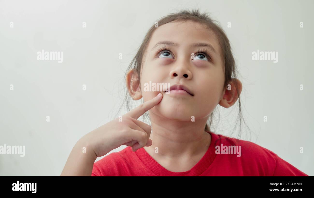 Little Asian Girl looks like thinking something Stock Photo - Alamy