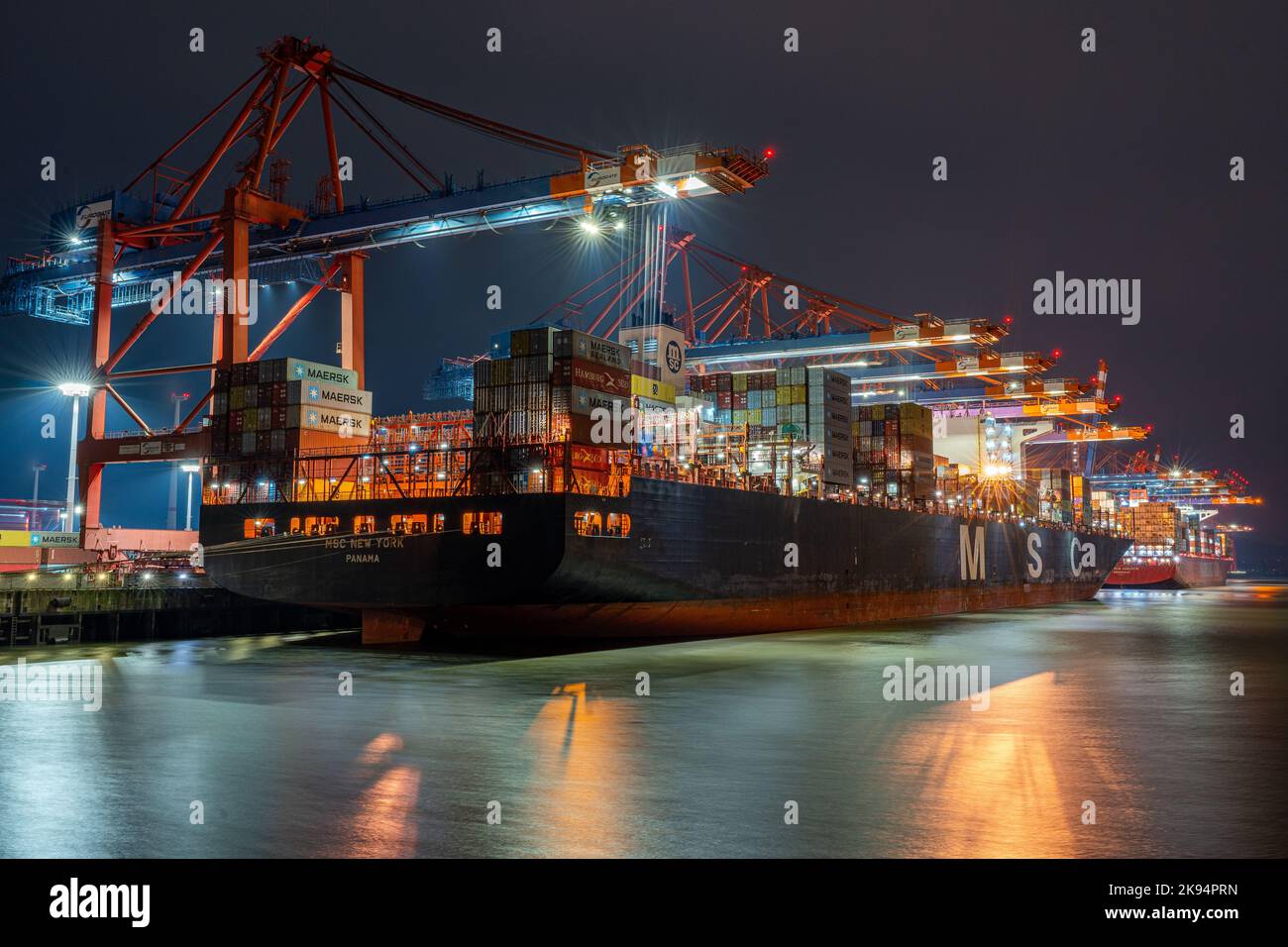 A huge containership in the harbor at night Stock Photo - Alamy