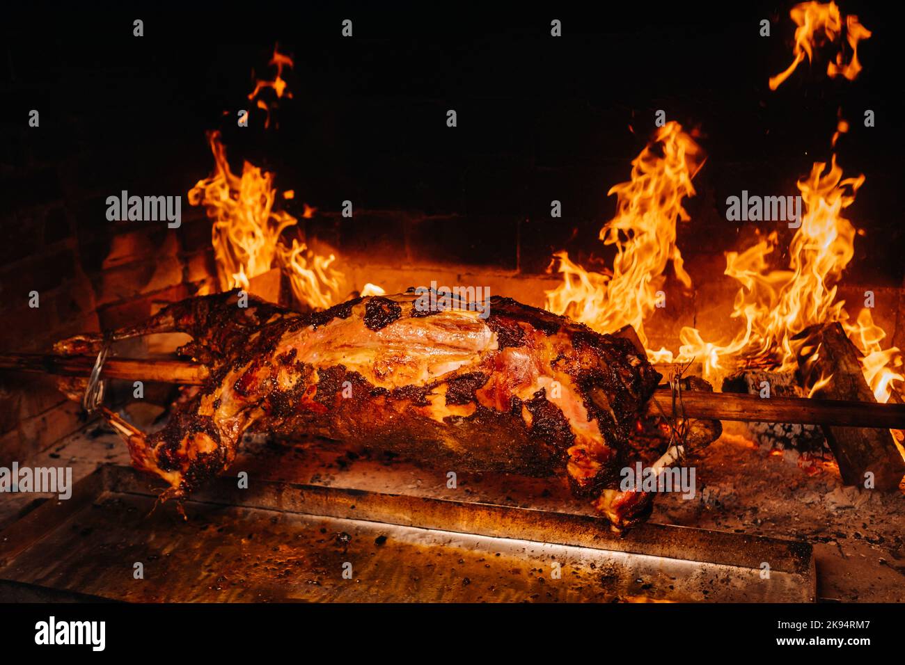 The lamb is cooked entirely on a spit on the fire. Cooking Stock Photo ...