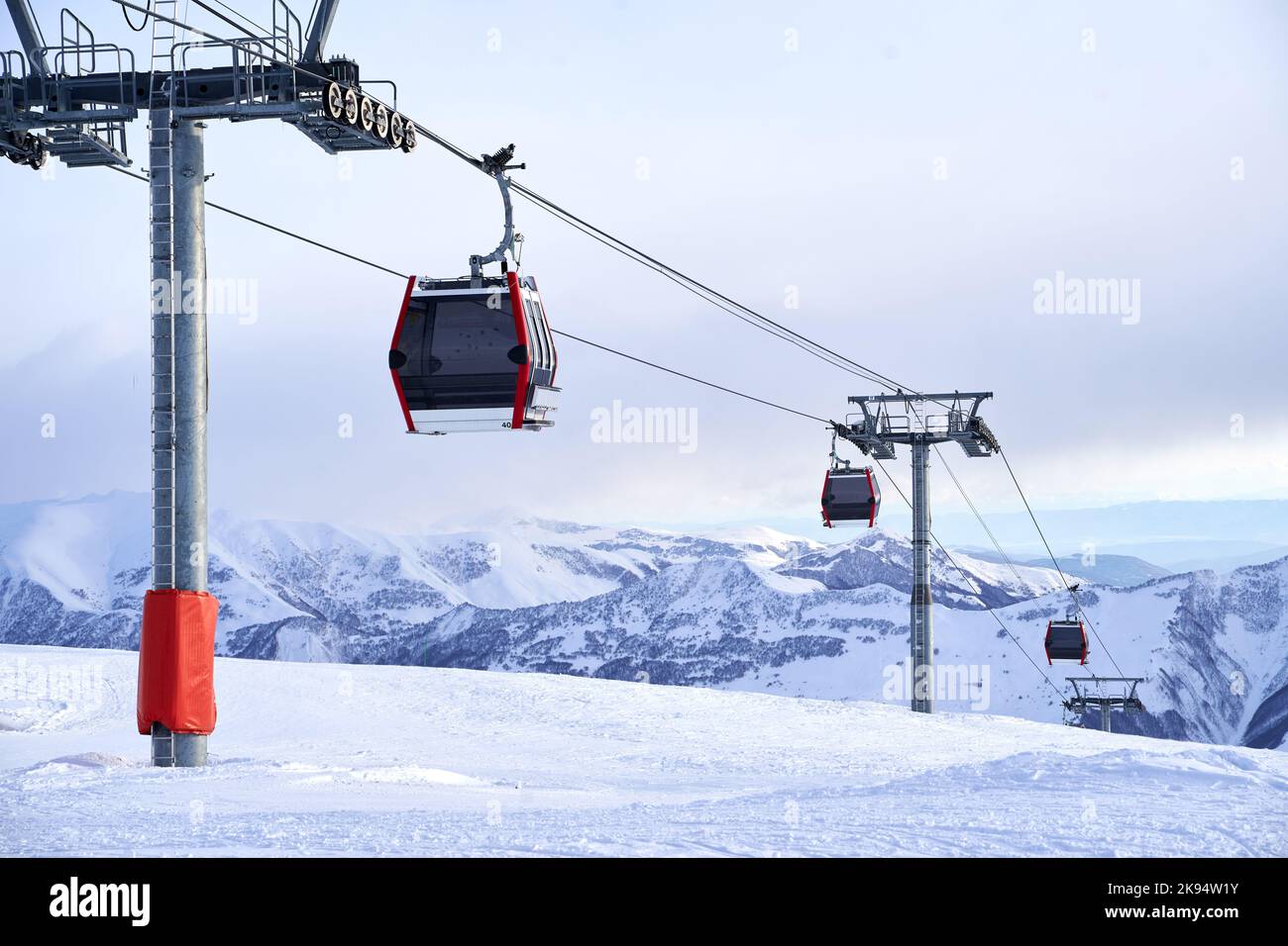 Cable car gondola at ski resort with snowy mountains on background ...