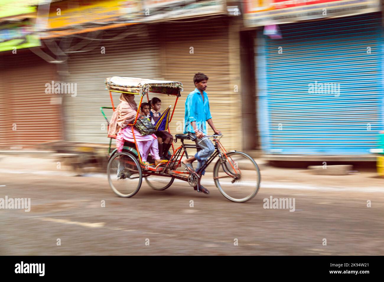DELHI, INDIA - OCT 16: Rickshaw rider transports passenger early ...