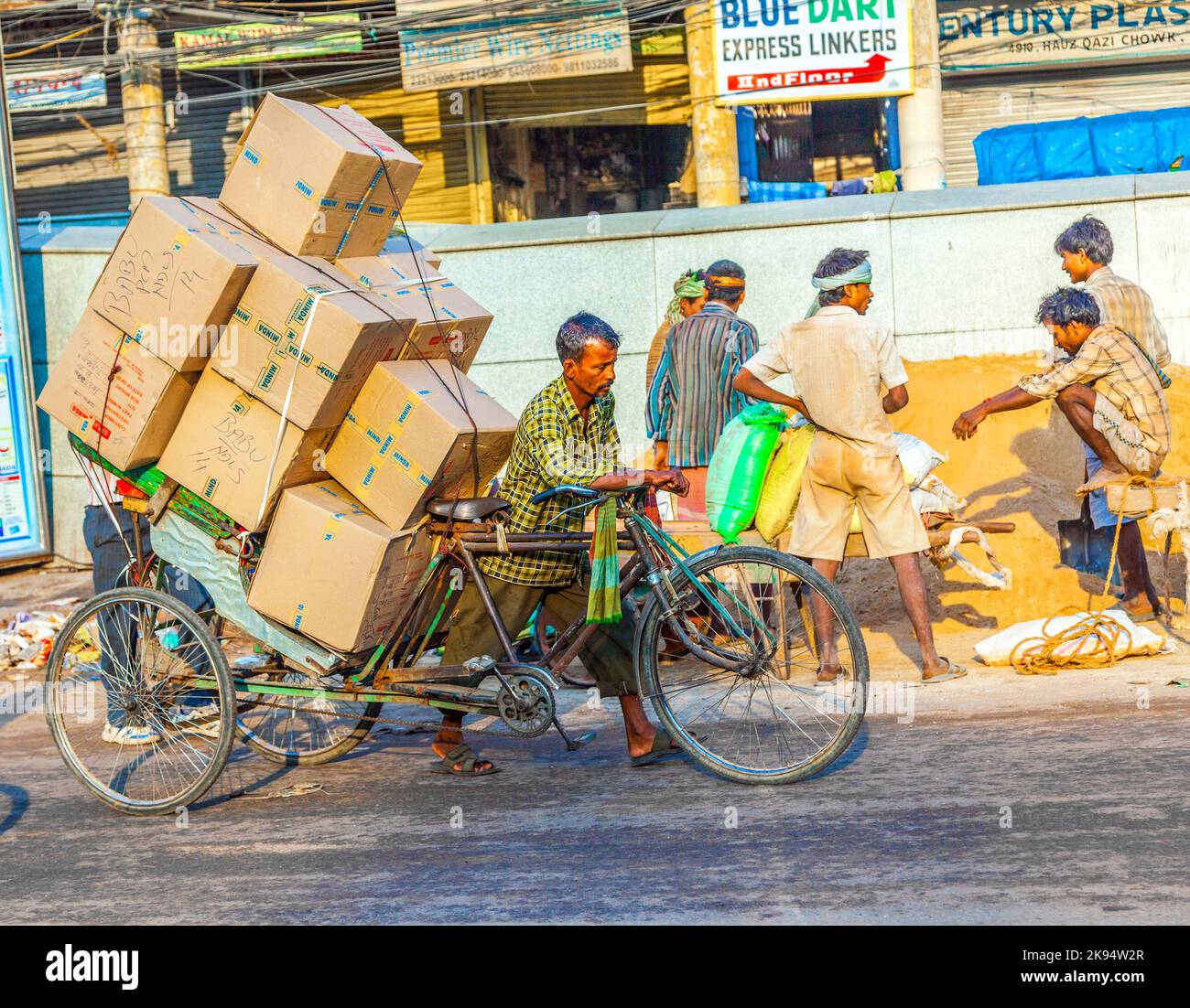 DELHI, INDIA - OCT 16: Rickshaw rider transports heavy goods early ...