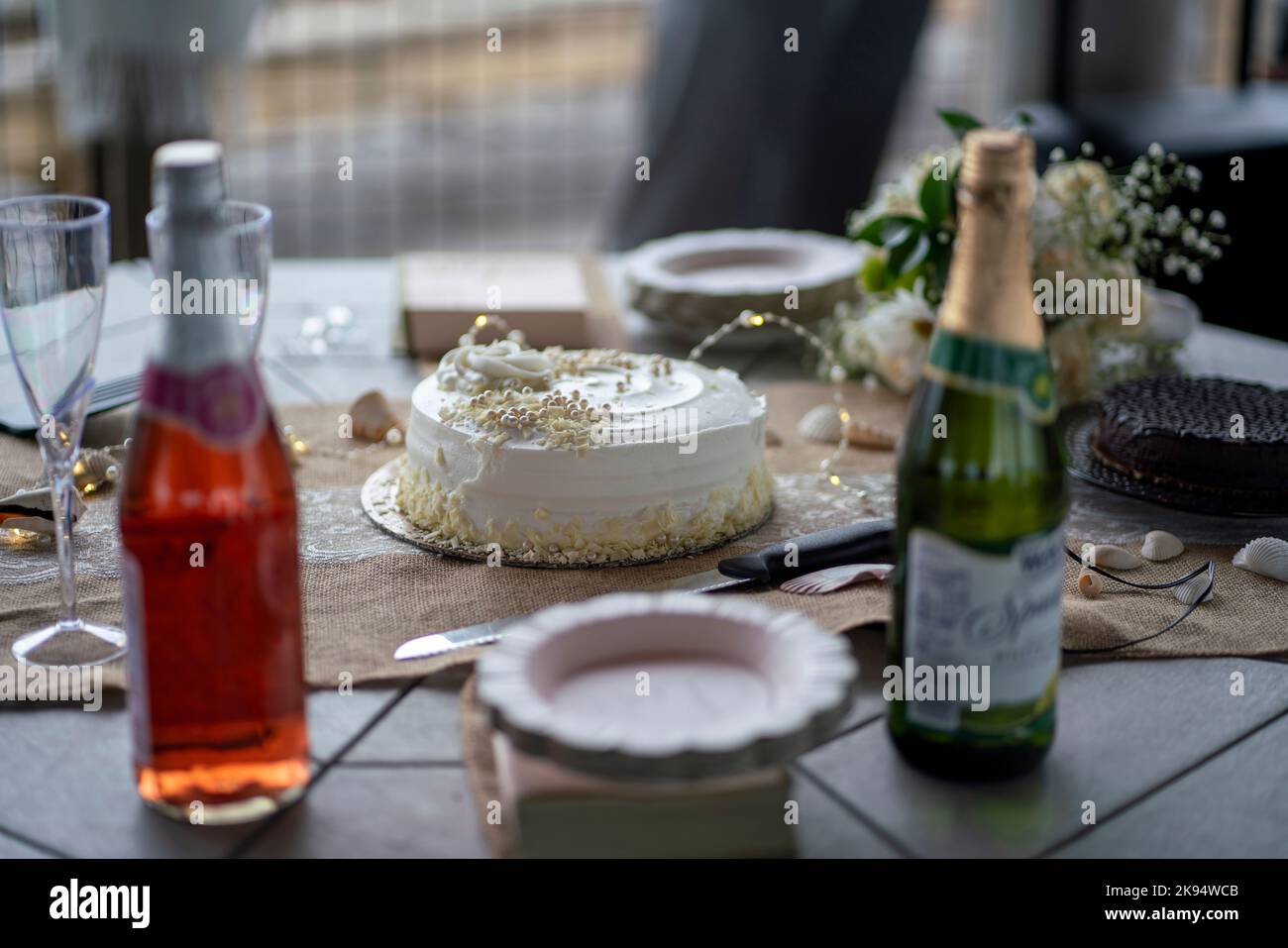 A white party cake on the table with decorations and alcohol Stock ...