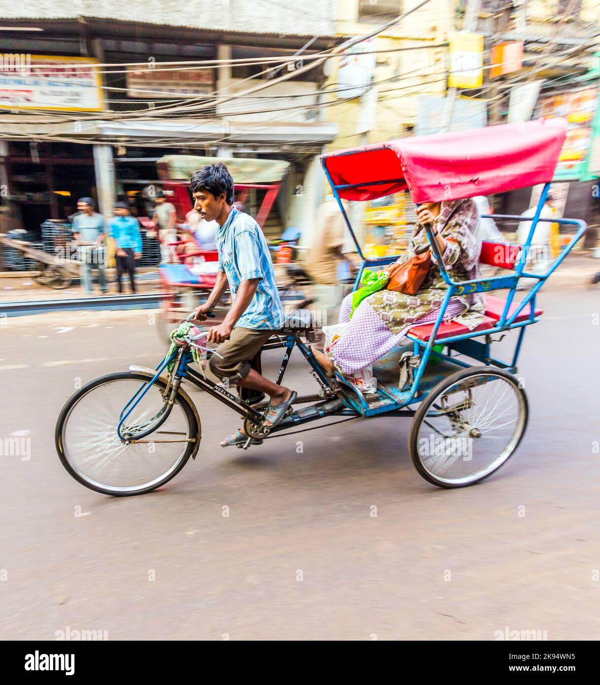 DELHI, INDIA - OCT 16: Rickshaw rider transports passenger early ...