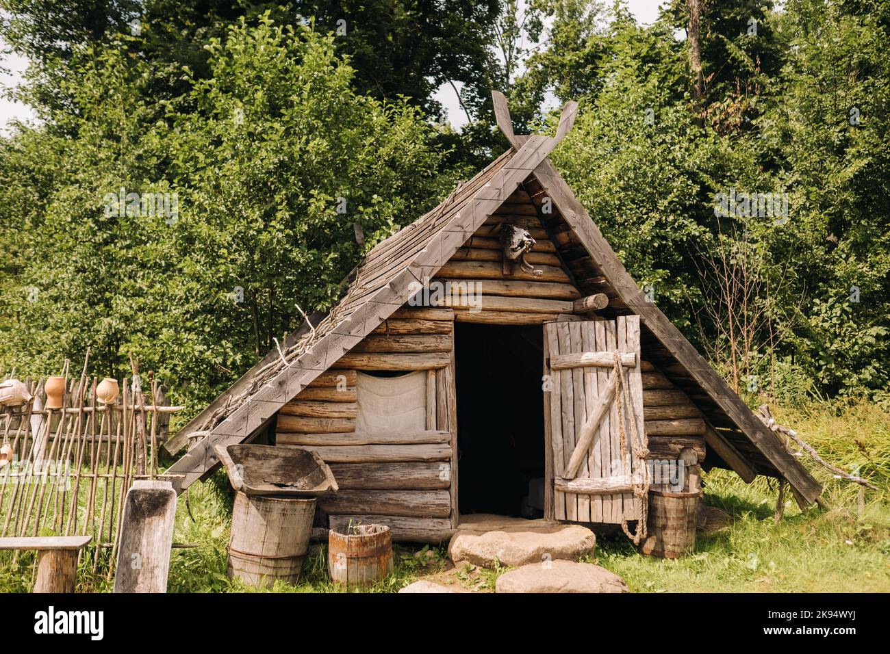Triangular log houses with wooden roofs in an old medieval village ...