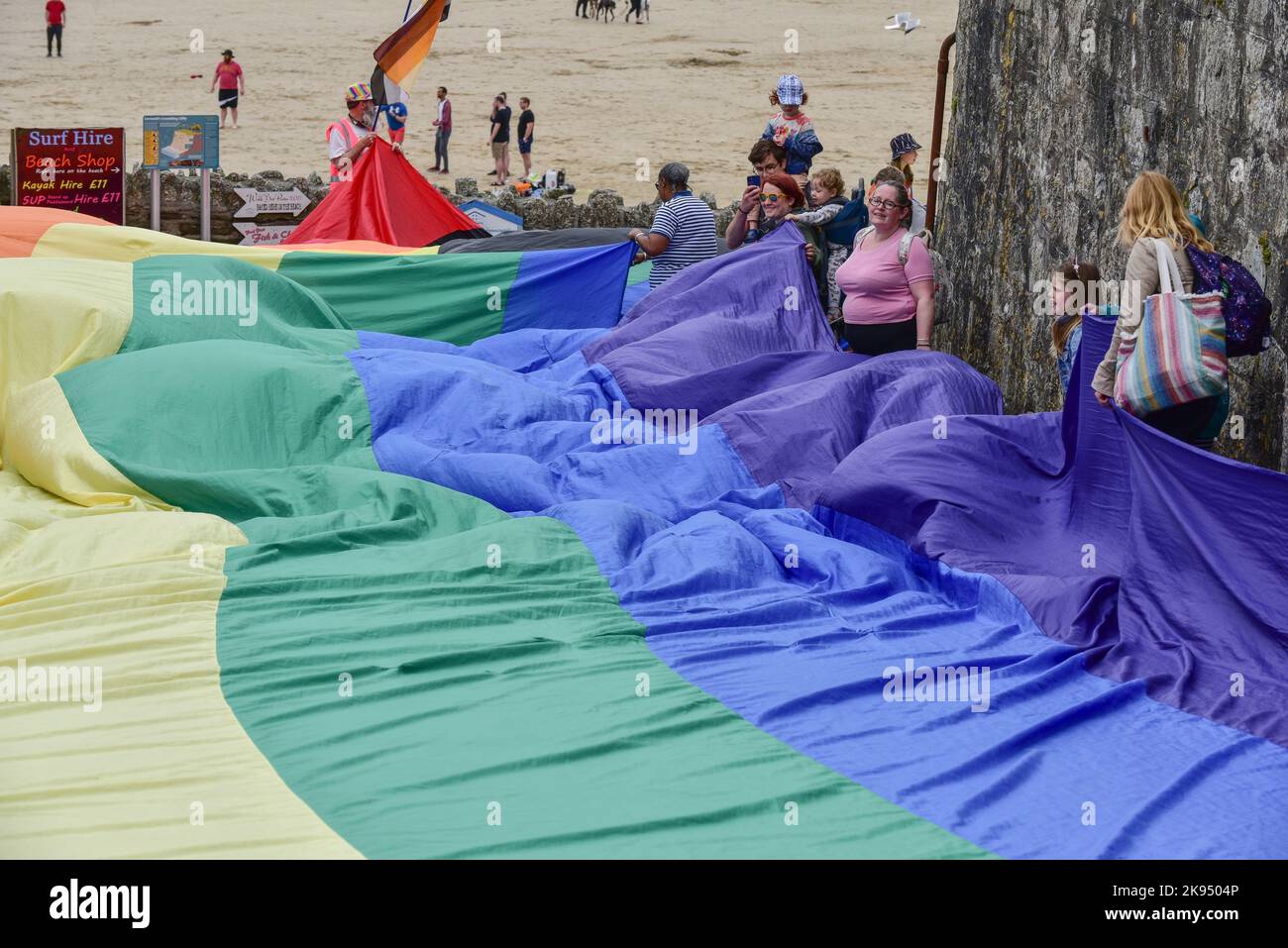 The huge vibrant colourful Cornwall Prides Pride flag banner held by ...