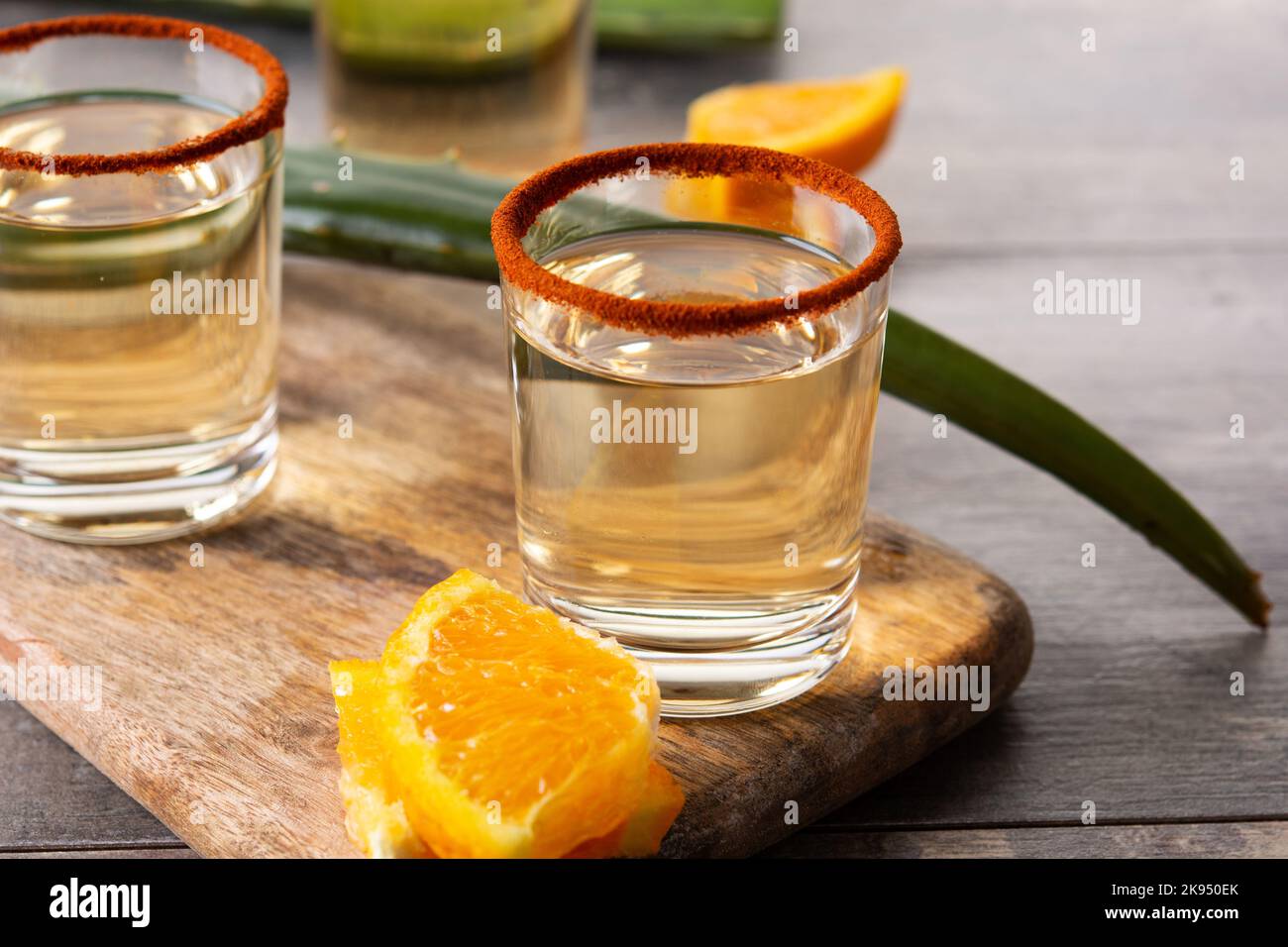 Mezcal Mexican drink with orange slices and worm salt on wooden table ...