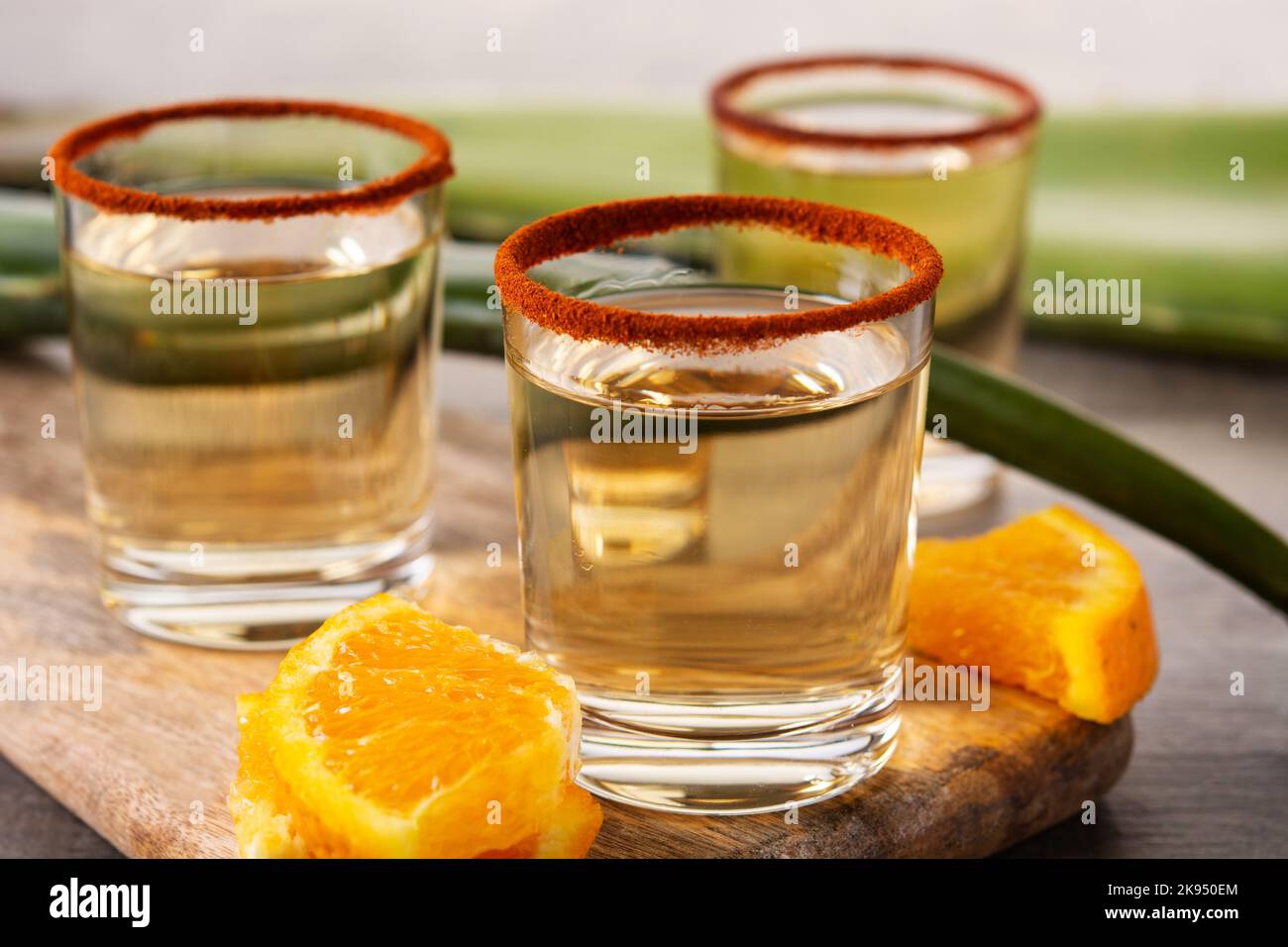 Mezcal Mexican drink with orange slices and worm salt on wooden table ...