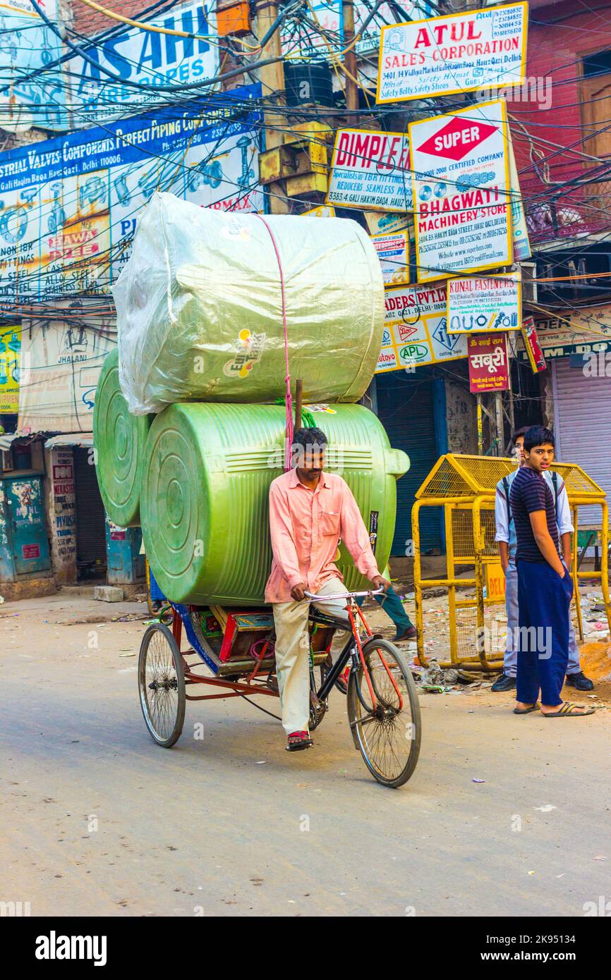 DELHI, INDIA - NOV 10: Rickshaw rider transports heavy load early ...