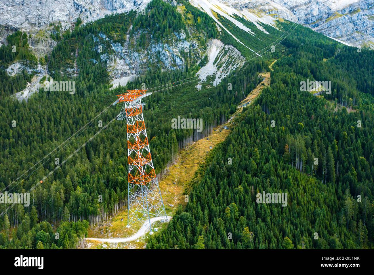 Power line pylon high in the mountains surrounded by trees, aerial view ...