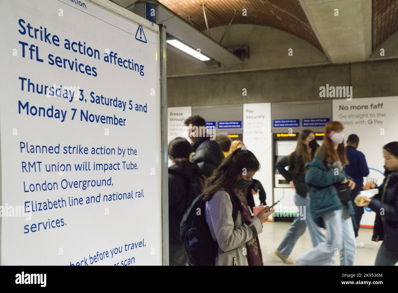 London, UK, 25 October 2022: Passengers pass a poster at London Bridge ...