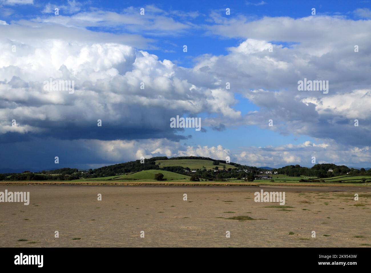Rain clouds and view across the River Kent Estuary at low tide at ...