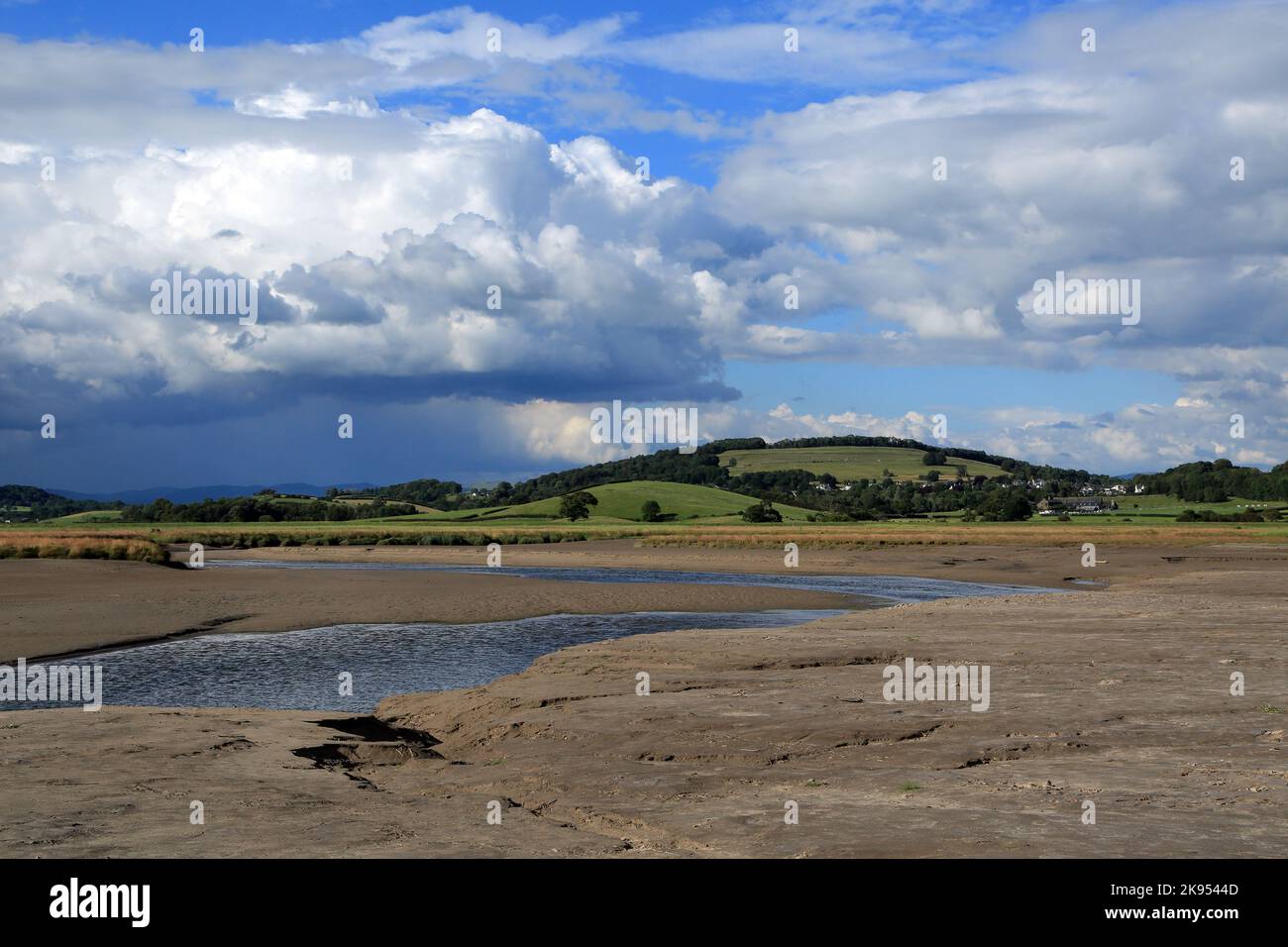 Rain clouds and view across the River Kent Estuary at low tide at ...