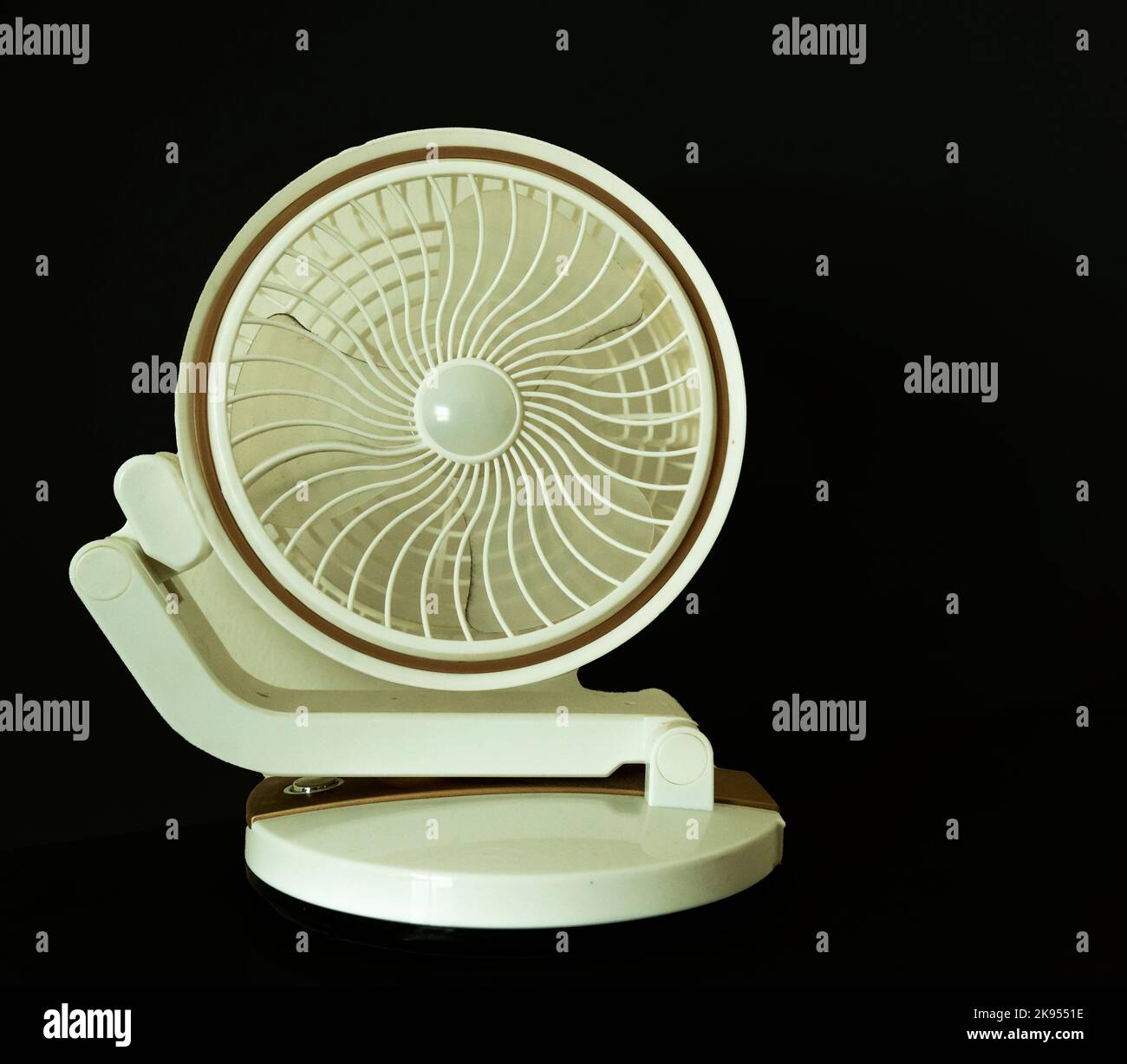 White table fan on a table with black background Stock Photo - Alamy