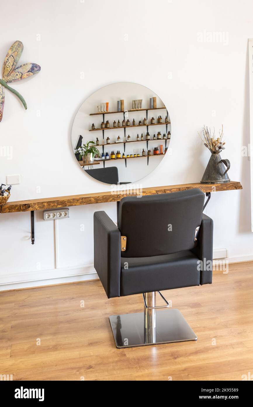 A modern chair and round mirror on a white wall in a room Stock Photo ...