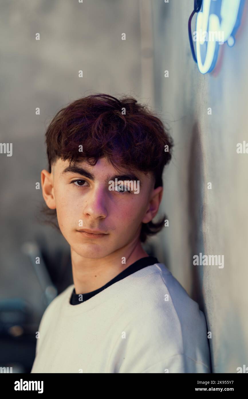 A vertical portrait of a young Caucasian boy with a fresh mullet ...