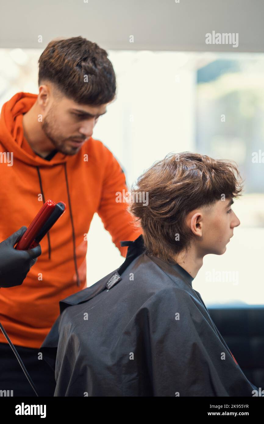 A vertical shot of a young Caucasian boy getting a fresh haircut Stock ...