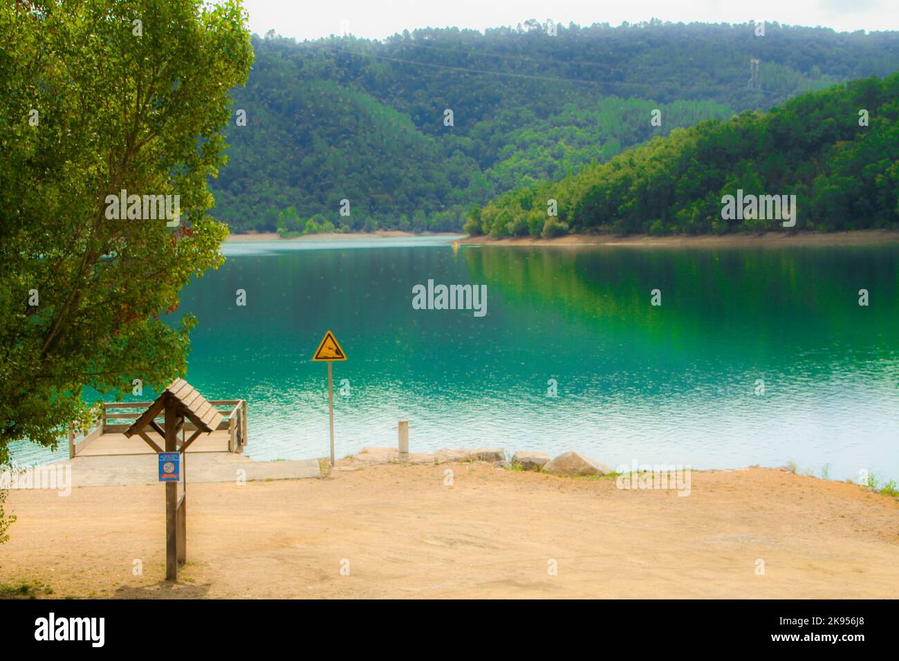 A cinematic azure lake surrounded by trees reflected on it Stock Photo ...