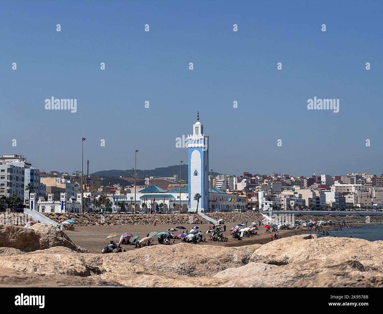 A group of people enjoying their summer holiday on the beach nearby ...