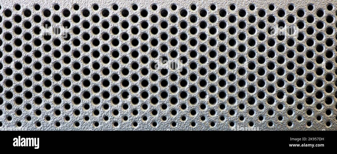 Grid in the form of round holes in a silvery plastic panel. Perforated ...
