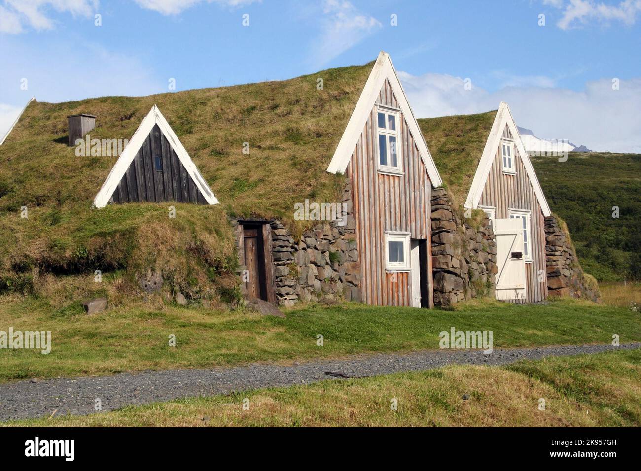 The facade of old turf houses against a blue cloudy sky Stock Photo - Alamy
