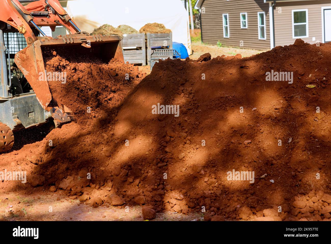 This small tractor is used in process of moving soil for landscaping on ...