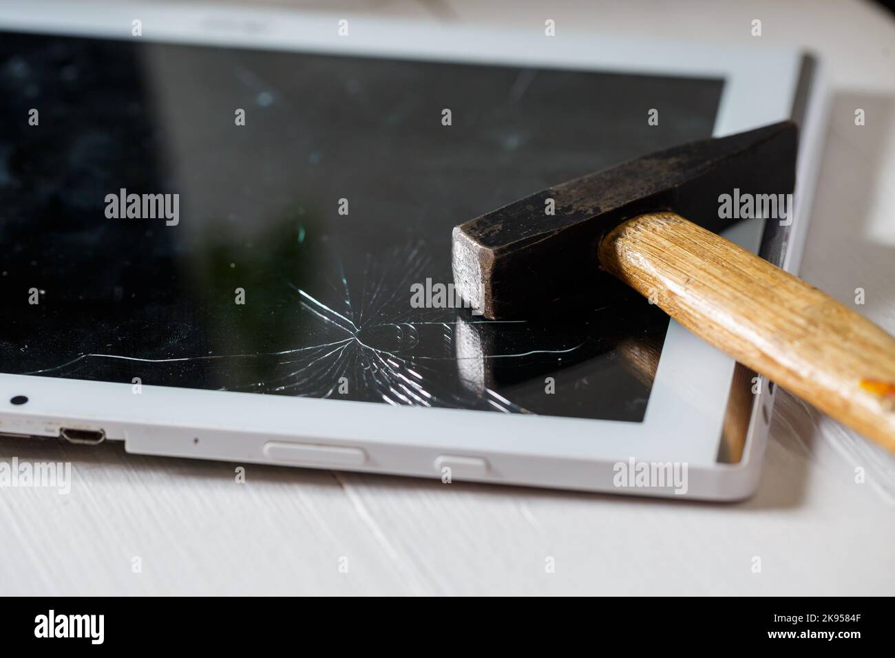 The hammer hits the broken touchscreen tablet, suggesting that it is ...