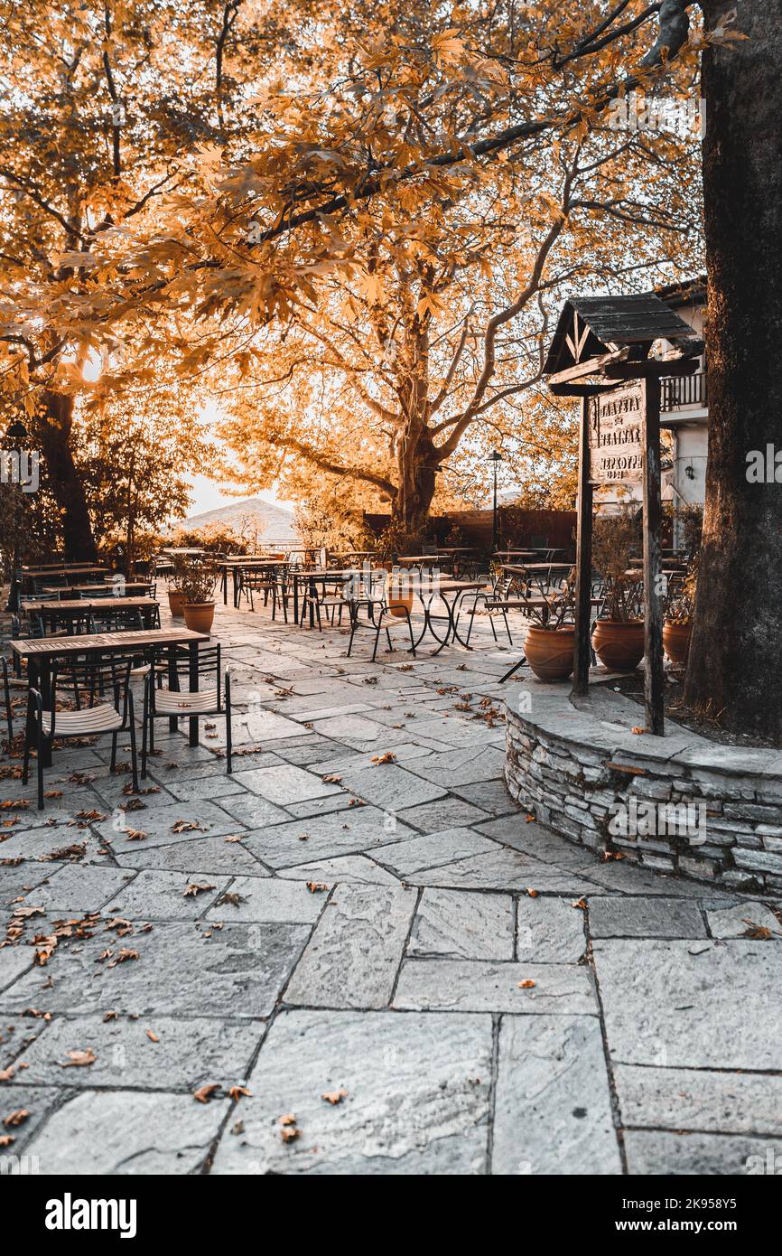 An autumn sunset over golden trees and an empty tavern restaurant in ...