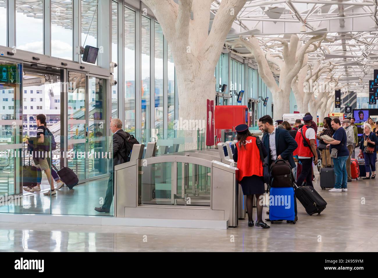 Travelers passing ticket gates in the concourse of the SNCF train ...