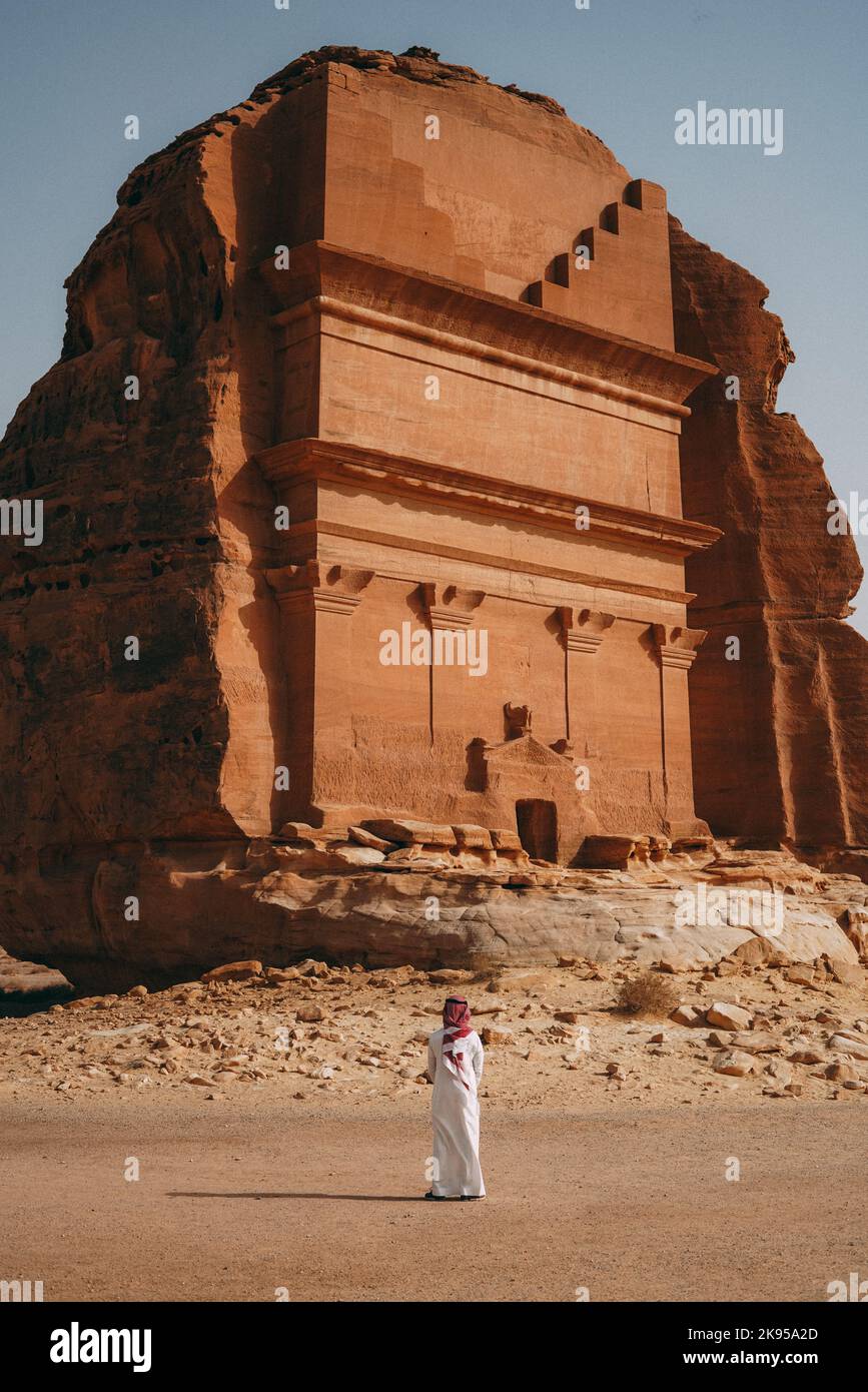 A vertical shot of a man standing in front of the Tomb of Lihyan son of ...