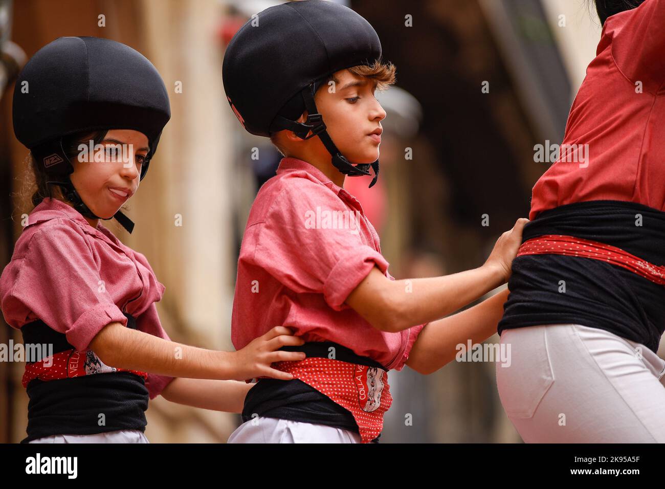 Children and adults of the Colla Vella dels Xiquets de Valls raising a ...