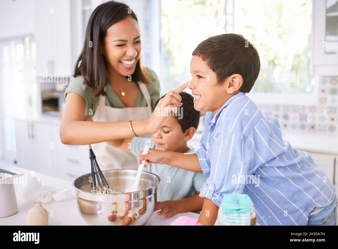 Family baking and mother teaching children to bake cake in the kitchen ...