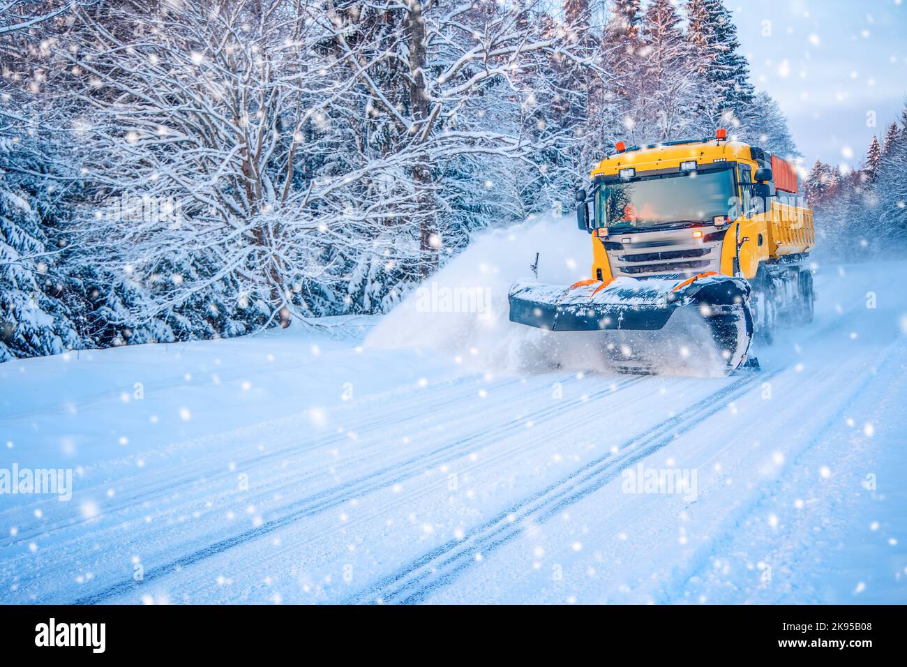 Snow plow truck cleaning road in snowstorm Stock Photo - Alamy