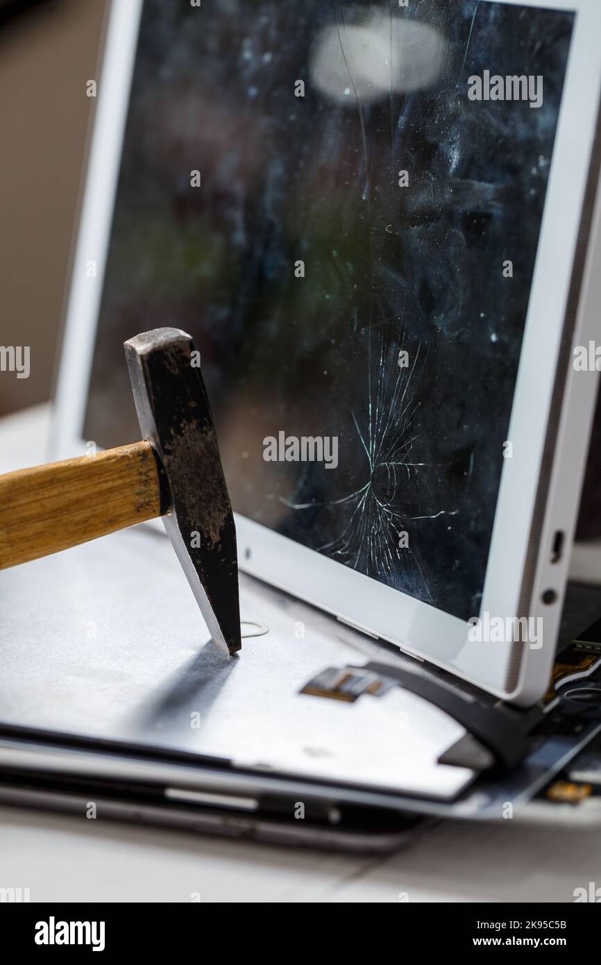 The hammer hits the broken touchscreen tablet, suggesting that it is ...