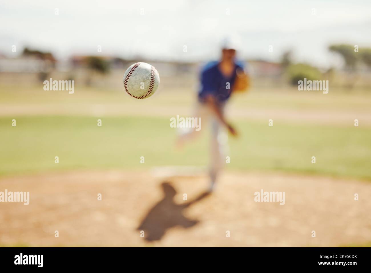 Sports, pitch and baseball ball in air, pitcher throwing it in match ...