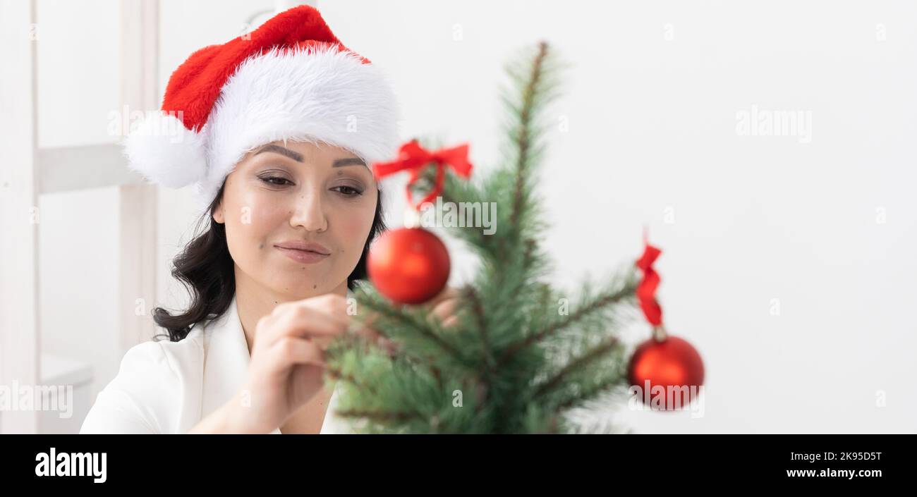 Banner smiling latin or indian business woman decorating christmas tree ...