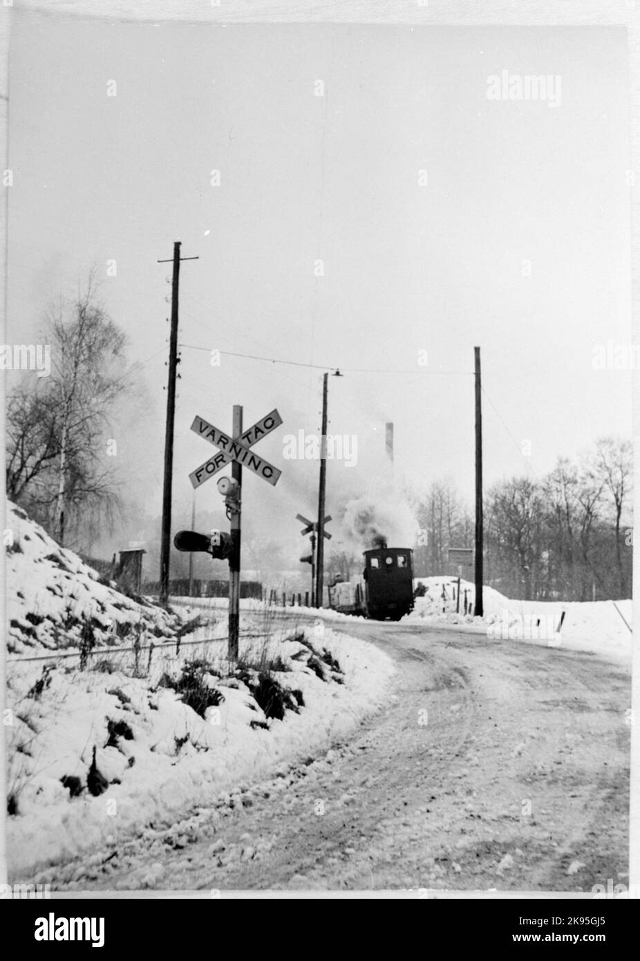 Steam trains in traffic on the road across the road. Clear warning sign ...