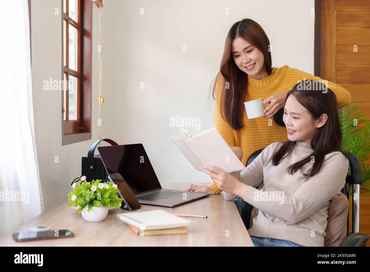 Two young Asian women working together in the office Stock Photo - Alamy