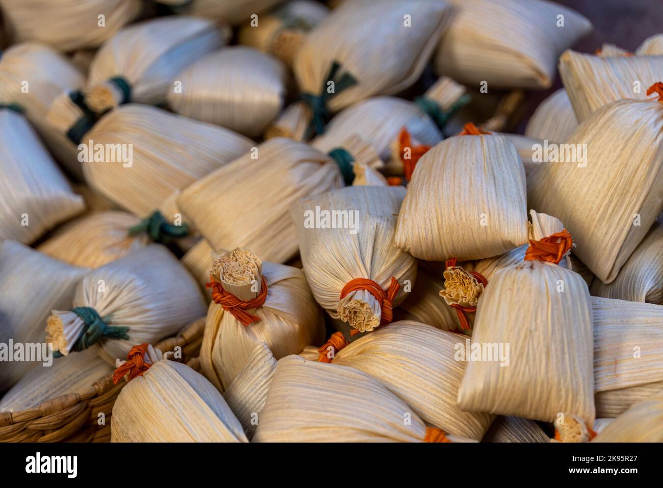 A pile of Mexican tamales with colored ribbons Stock Photo - Alamy