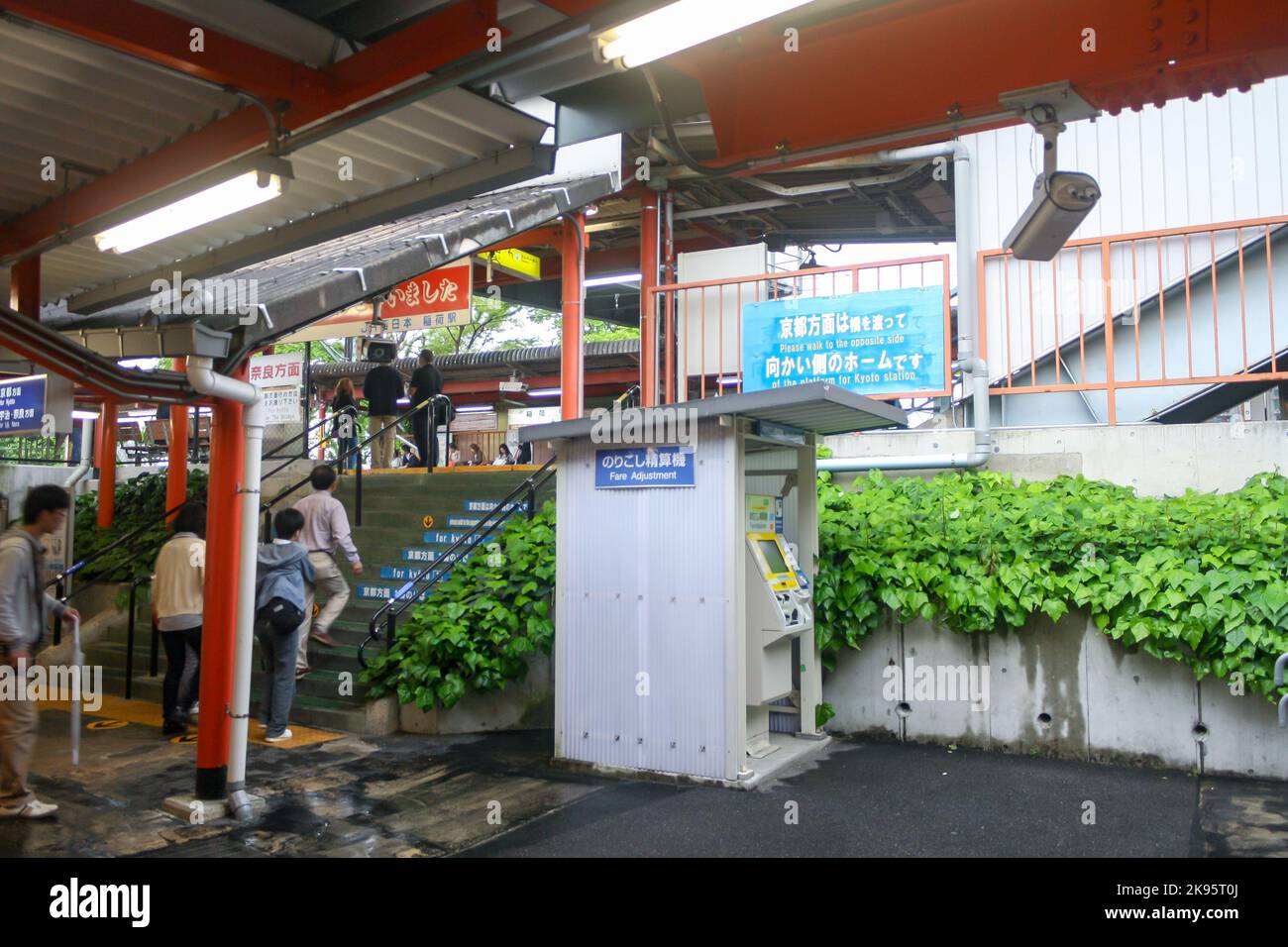 Automatic ticket machine inside Inari JR station with people walking on ...